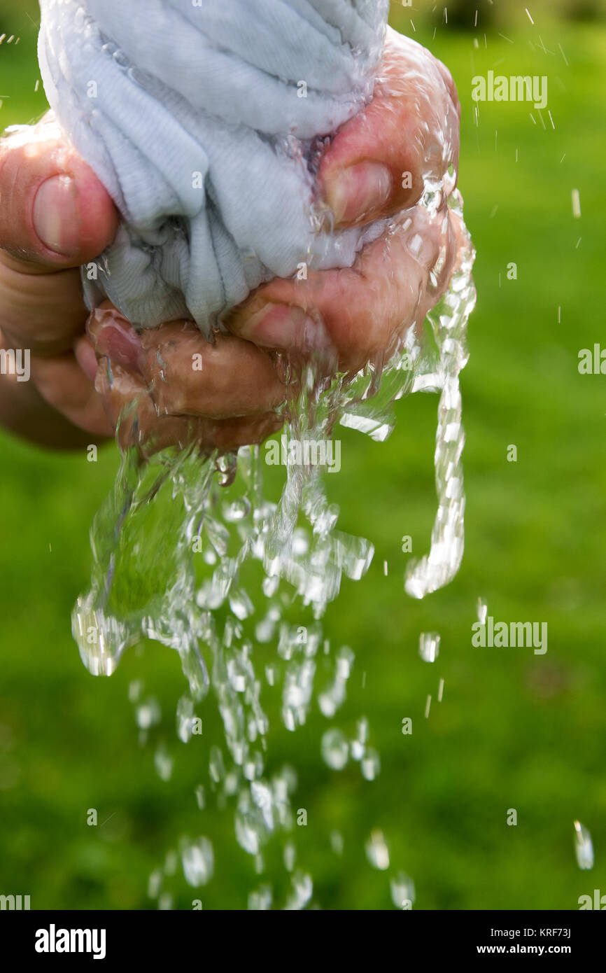 Hands squeeze wet cloth Stock Photo - Alamy