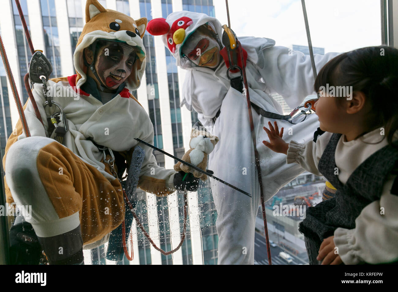 Tokyo, Japan. 20th December, 2017. A girl looks at window cleaners ...