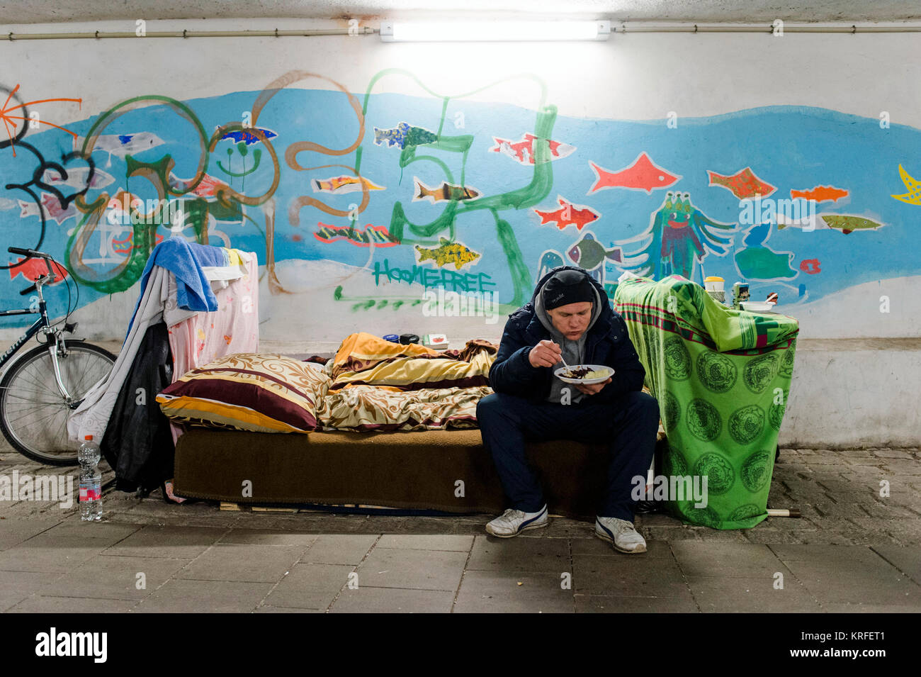 A homeless man, who lives in a pedestrian underpass, sits on his bed ...