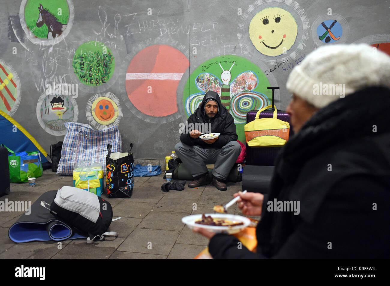 Homeless people, who live in a pedestrian underpass, eat a warm meal ...