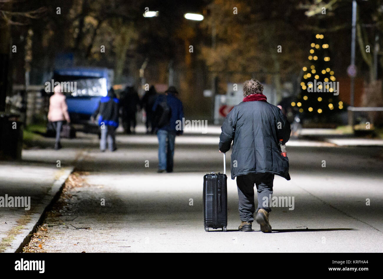 Munich, Germany. 14th Dec, 2017. Homeless people walk towards the night ...