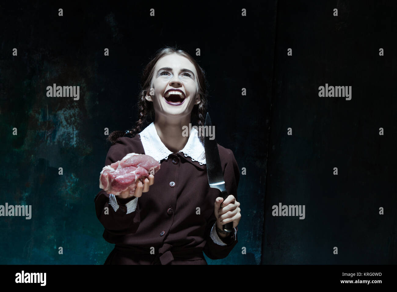 Bloody Halloween theme: crazy girl with a knife and raw meat Stock ...