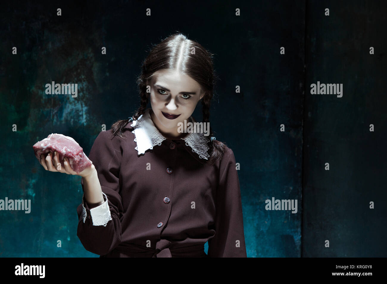 Bloody Halloween theme: crazy girl with raw meat Stock Photo - Alamy