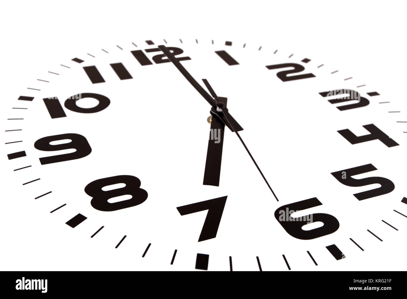 Clock isolated on white marking the seven o'clock hour. The main focus ...