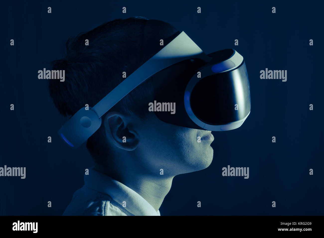 Young man plays in computer game with VR helmet and lighted from the ...