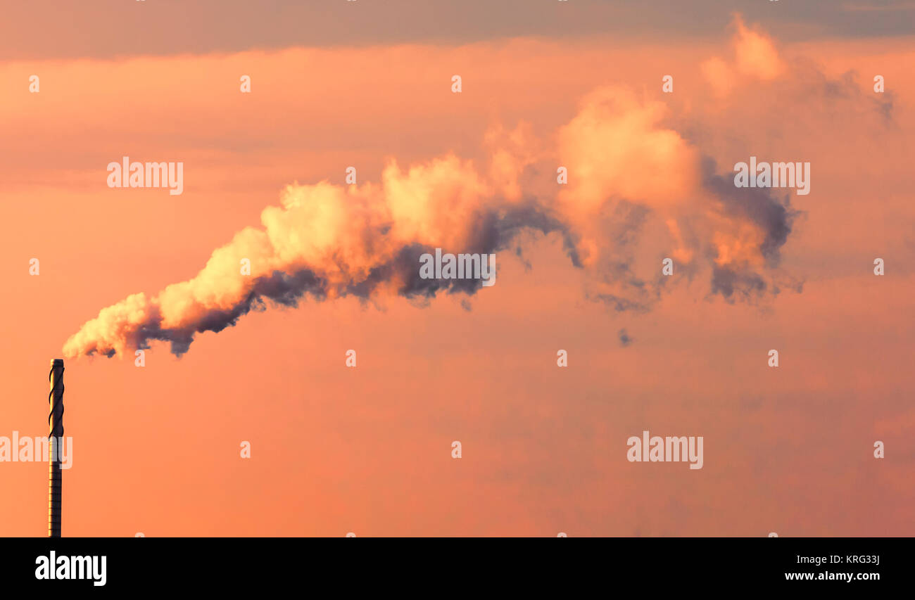 Pollution clouds coming out from a industrial chimney at sunset Stock ...