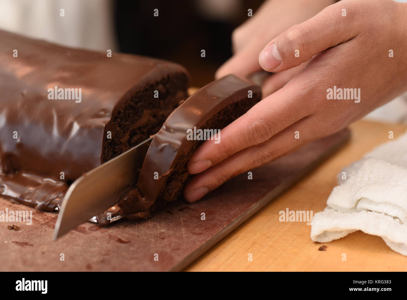 Chocolate roll being sliced with a knife Stock Photo - Alamy