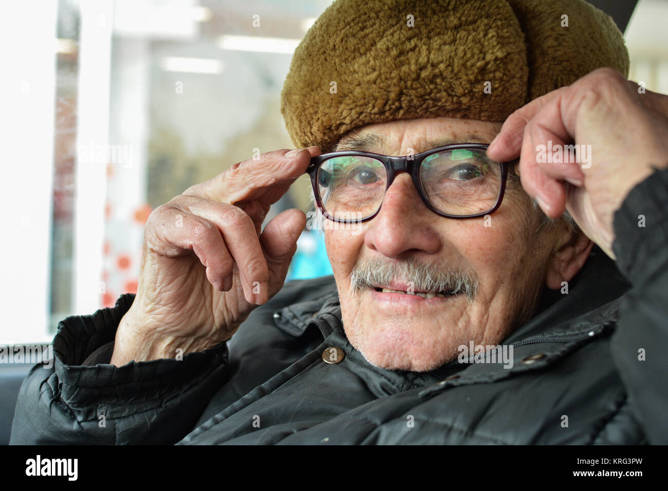 Portrait of active, vital elderly man with gray moustache and fur hat ...