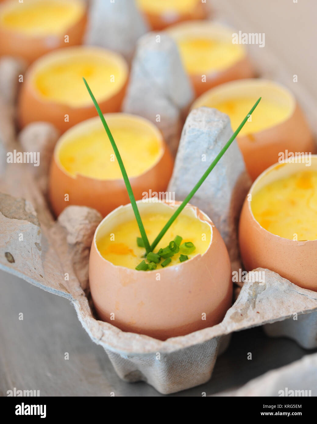 Egge custard in egg shells with chive garnish Stock Photo - Alamy