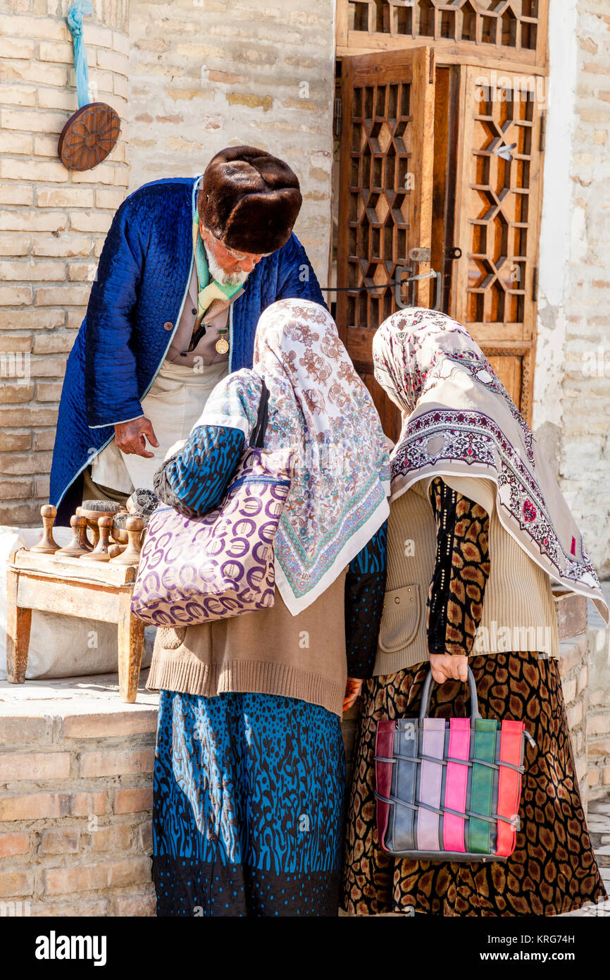 An Elderly Uzbek Man Sells Souvenirs From A Stall In The Market ...