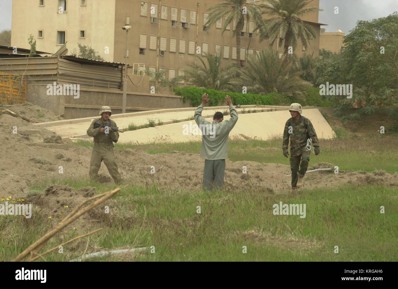 An Iraqi civilian man holds his arms up in surrender after being caught ...