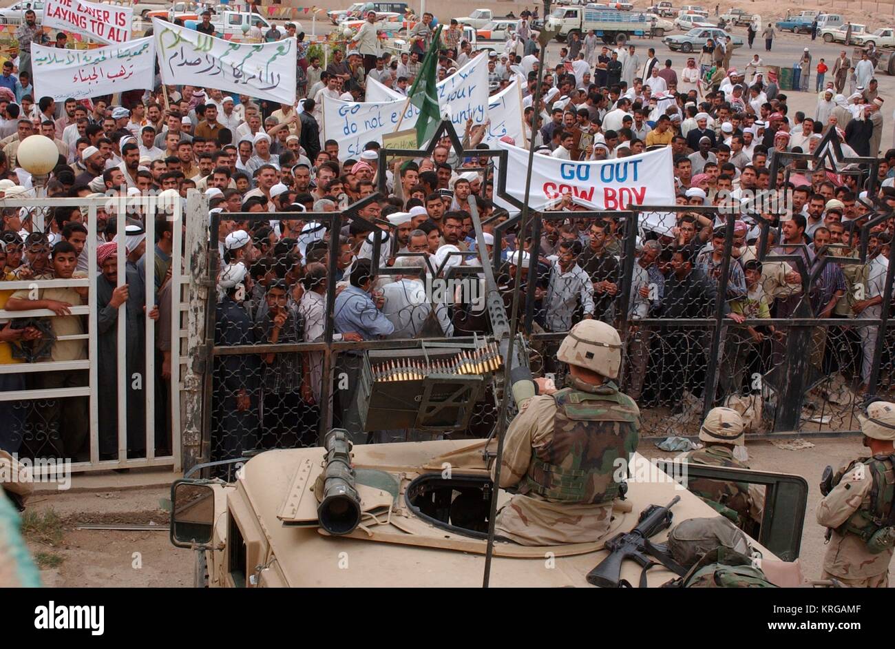 U.S. soldiers watch from atop tank guard posts as Iraqi civilians ...