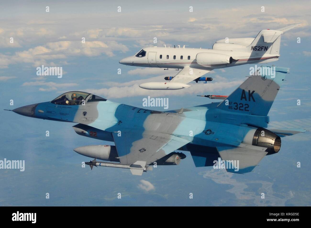 A General Dynamics F-16 Fighting Falcon fighter aircraft and Learjet ...