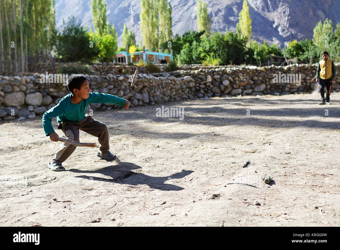Young boys, kids playing traditional game with sticks in dusty field in ...