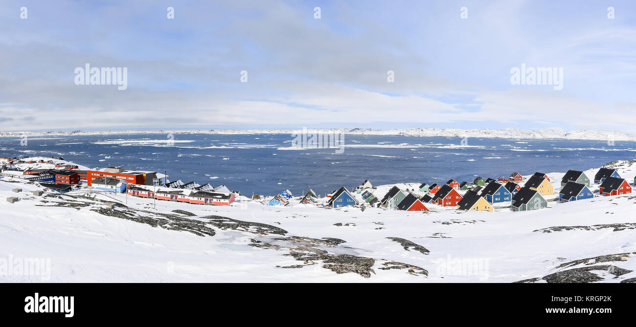 Colorful inuit houses at the fjord full of icebergs in a suburb of ...