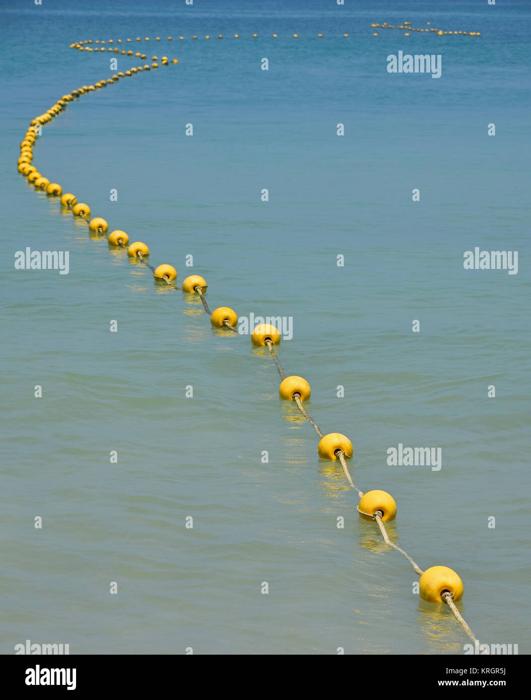 Chain of yellow buoys in blue sea water Stock Photo - Alamy