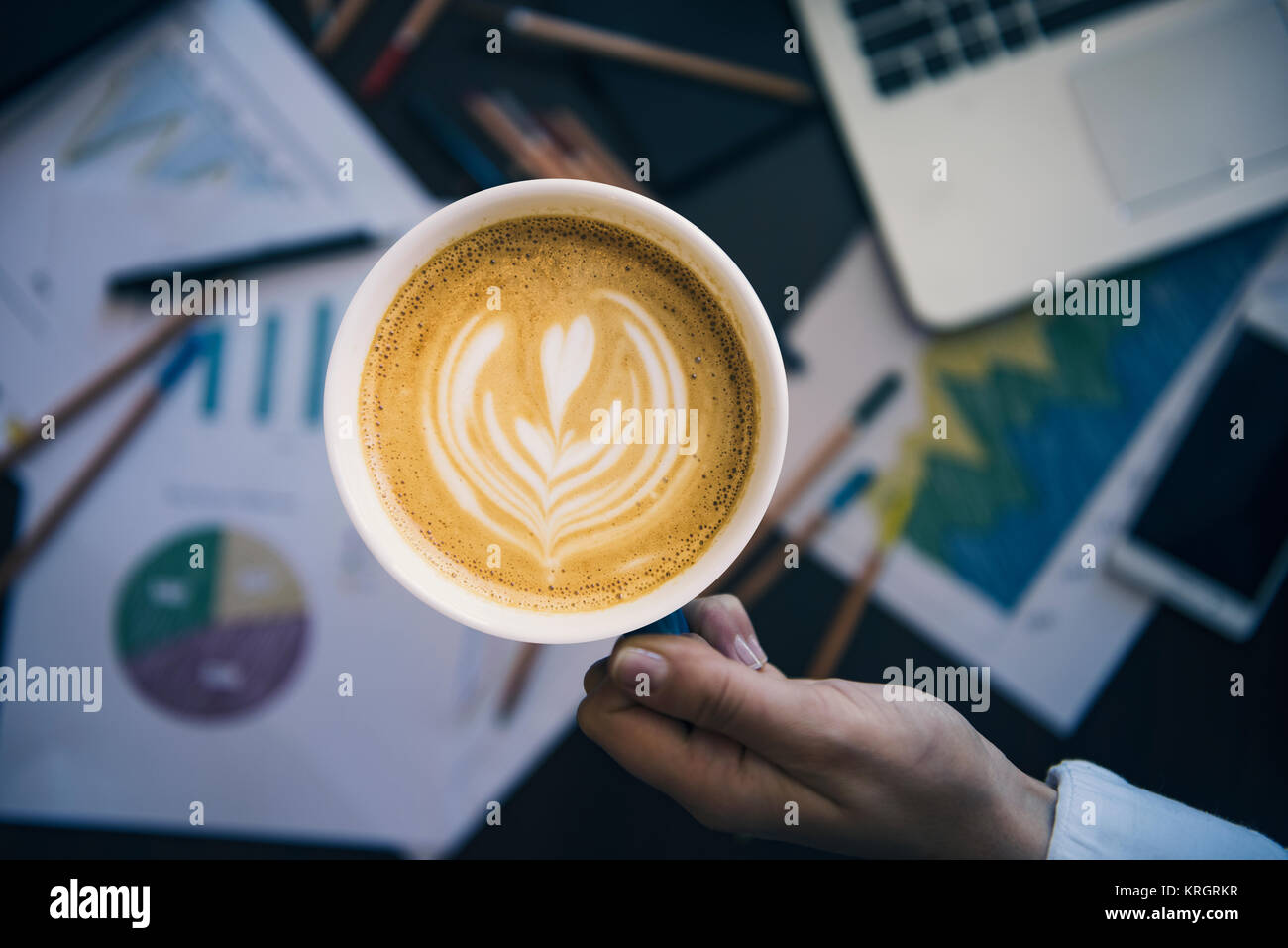 Coffee in focus and work office background Stock Photo - Alamy