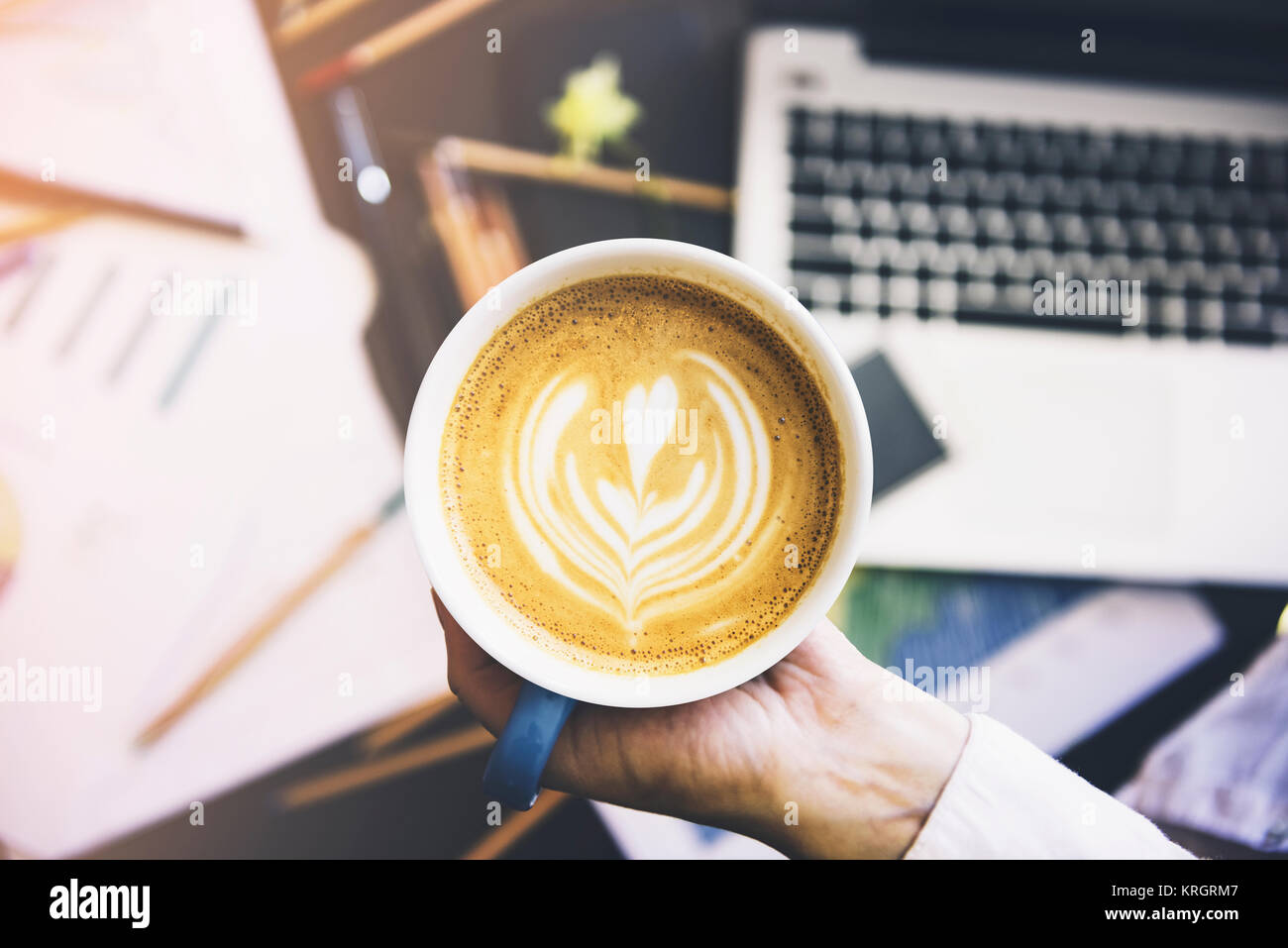 Coffee in focus and work office background Stock Photo - Alamy
