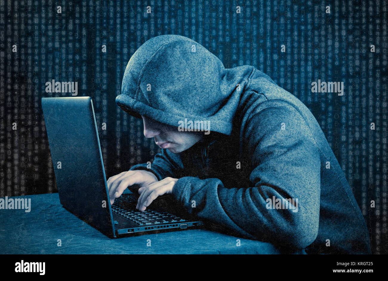 Hooded computer hacker with laptop Stock Photo - Alamy