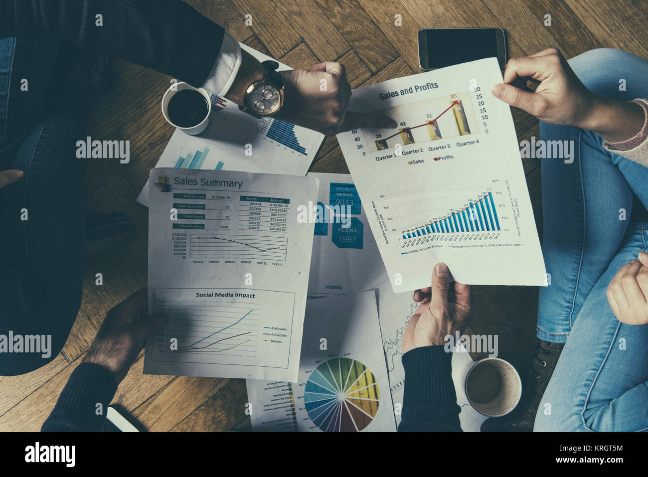 Team viewing business reports Stock Photo - Alamy