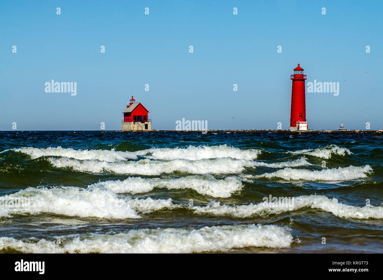 White-capped waves roll past the lighthouse and pier at Grand Haven, Michigan, on Lake Michigan ...