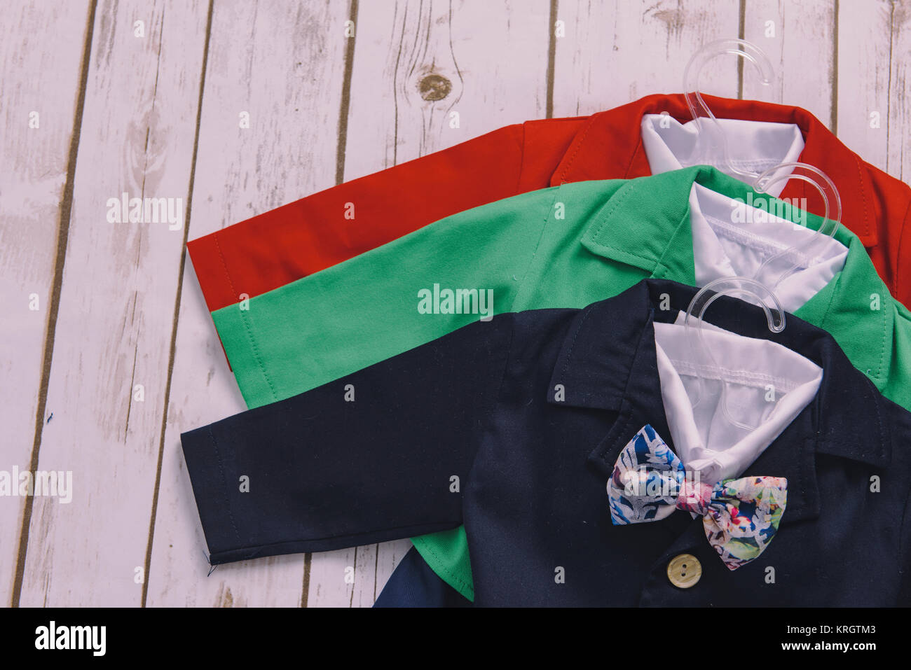 Children suits on a wood background Stock Photo - Alamy