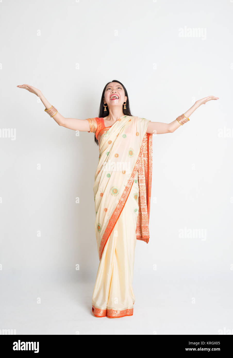 Woman in Indian sari dress hand raised looking up Stock Photo - Alamy
