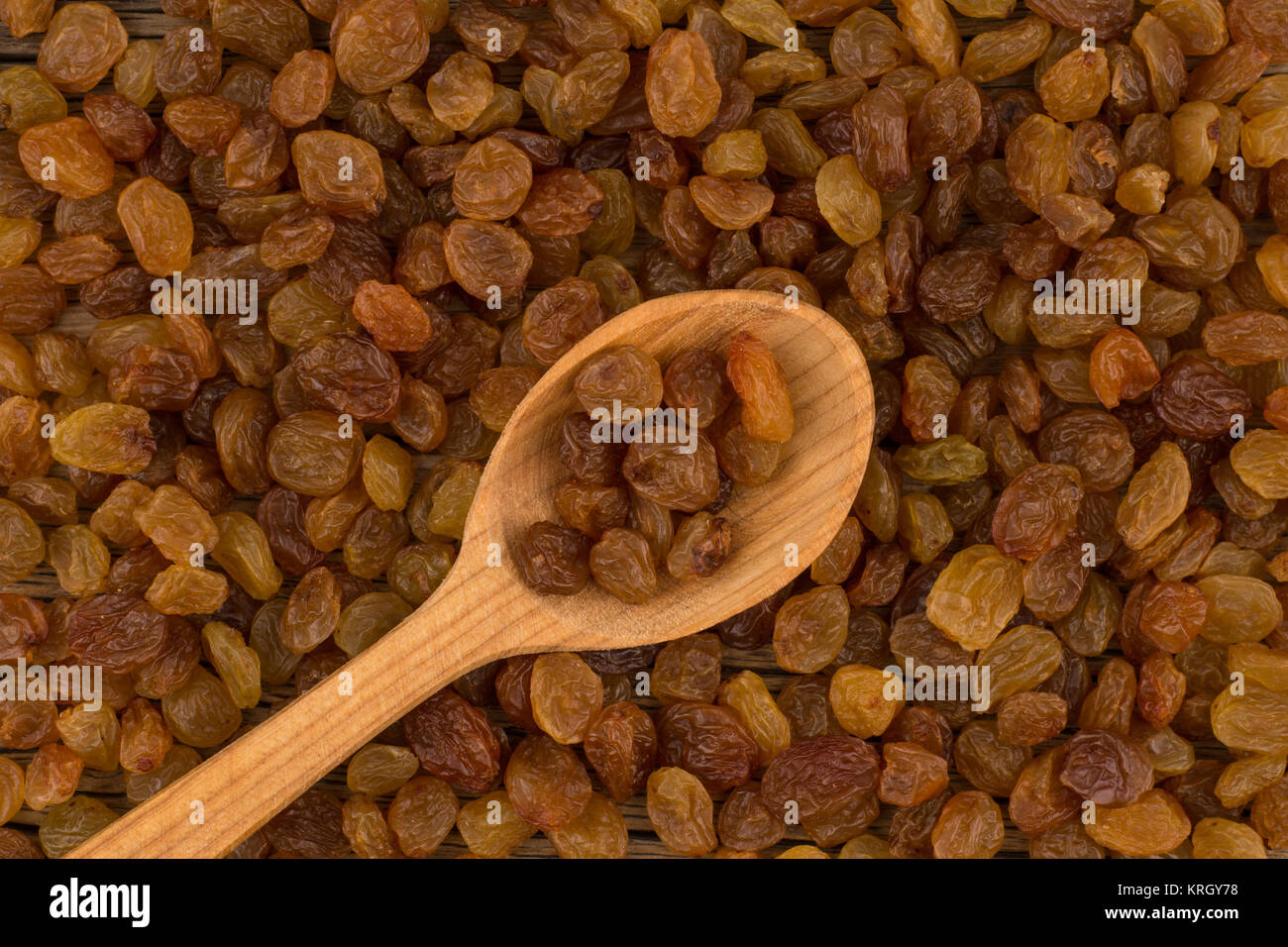 Raisins in wooden spoon and background of raisins Stock Photo - Alamy