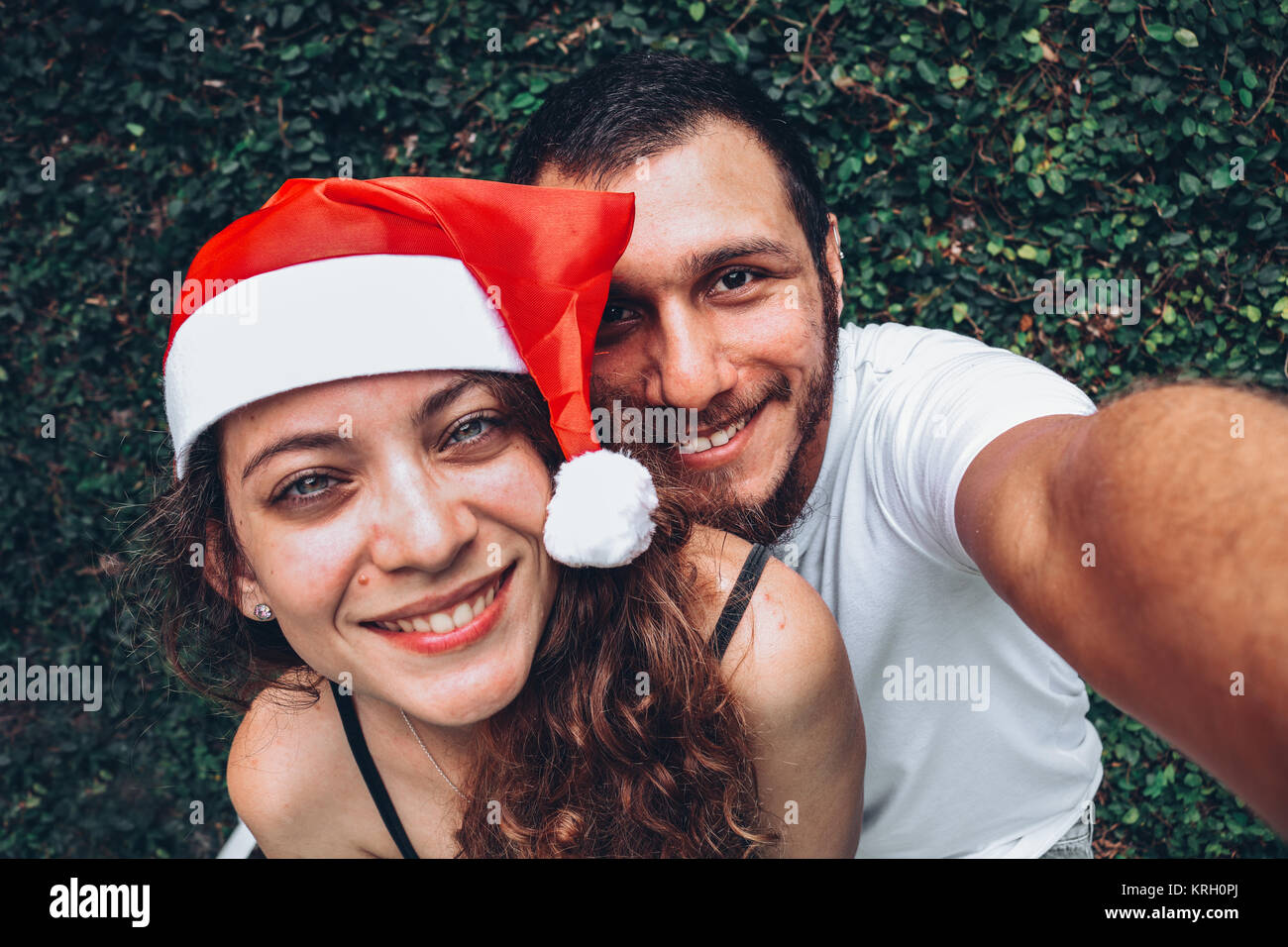Lovely couple take a selfie portrait, wearing a christmas cap, smiling ...