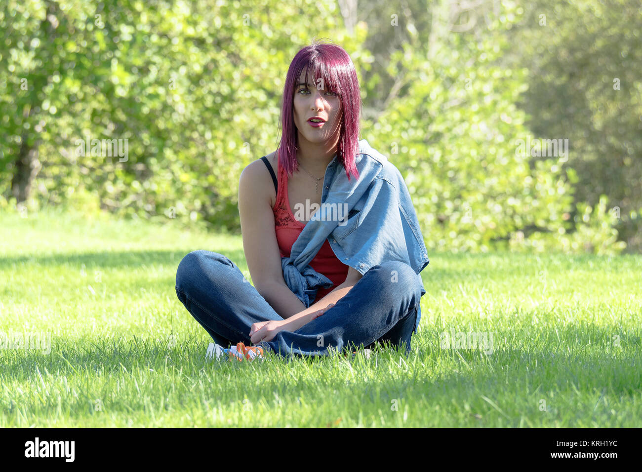 beautiful young woman sitting in the grass Stock Photo - Alamy