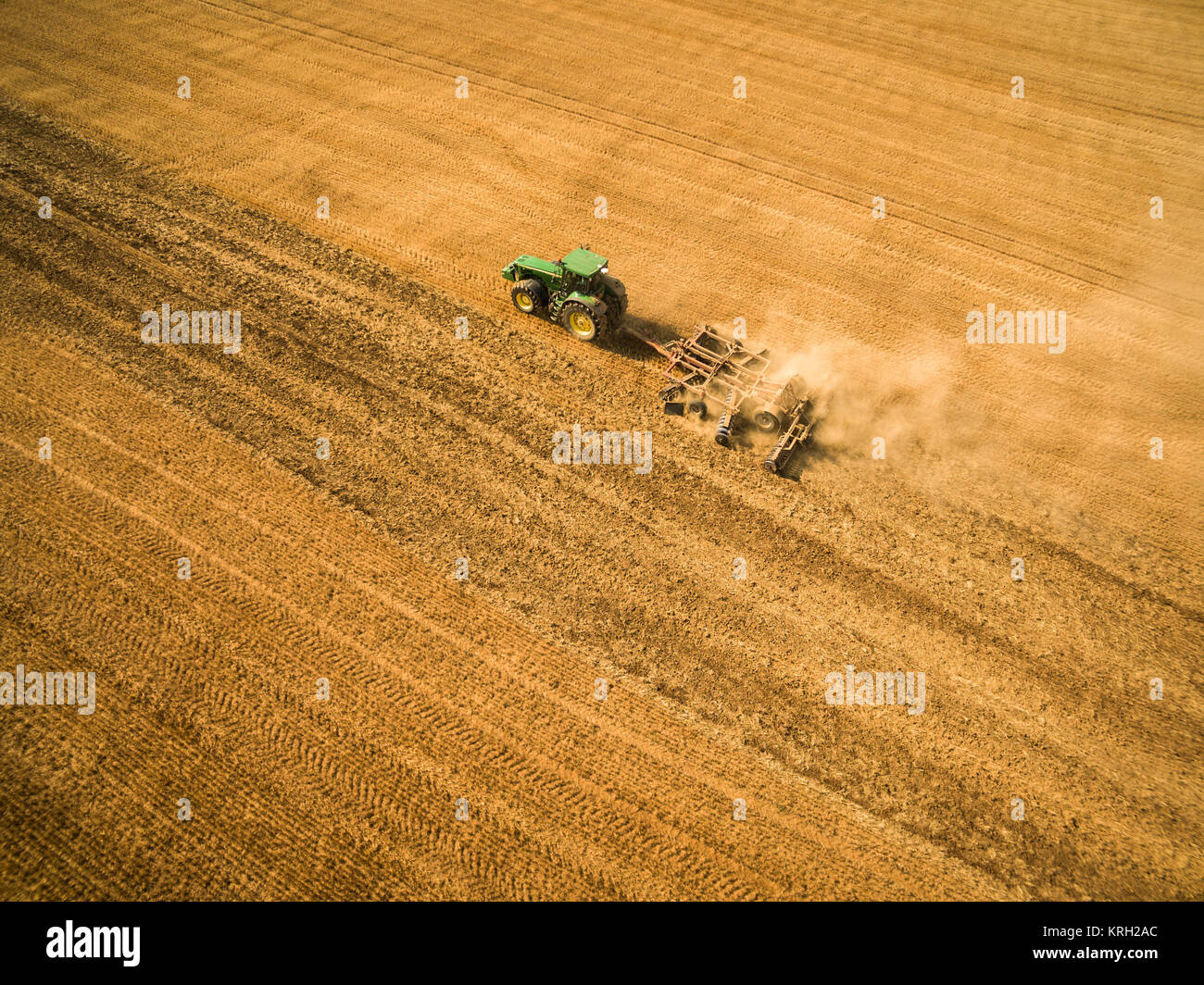Aerial view of a tractor working a field after harvest Stock Photo - Alamy