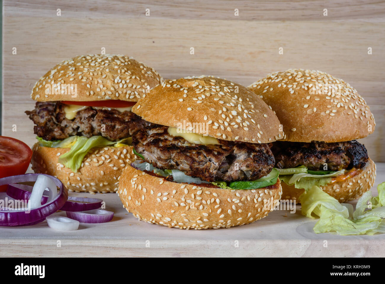 Three fresh hamburger lay on the board Stock Photo - Alamy