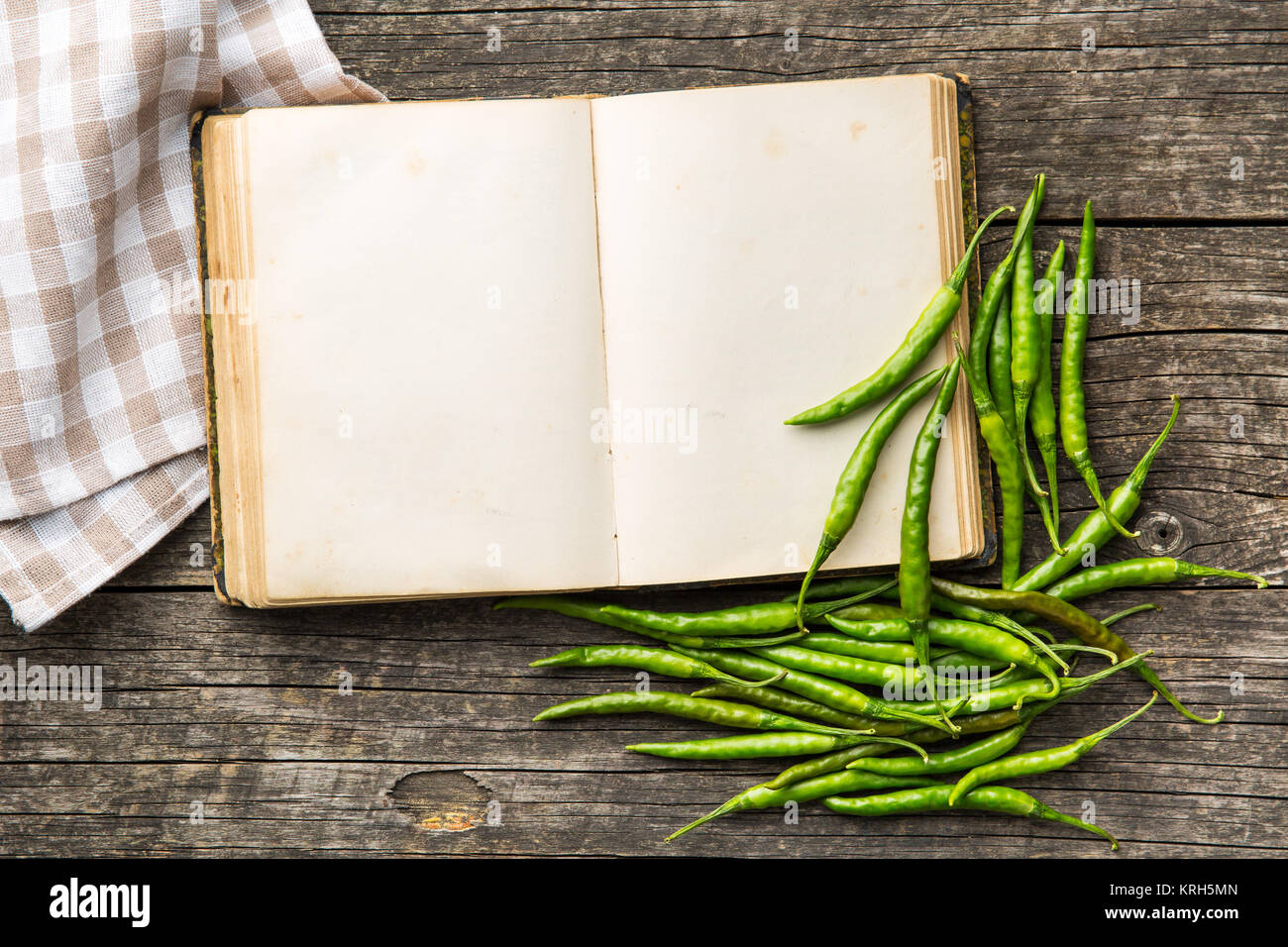 Recipe book and green chili peppers Stock Photo - Alamy