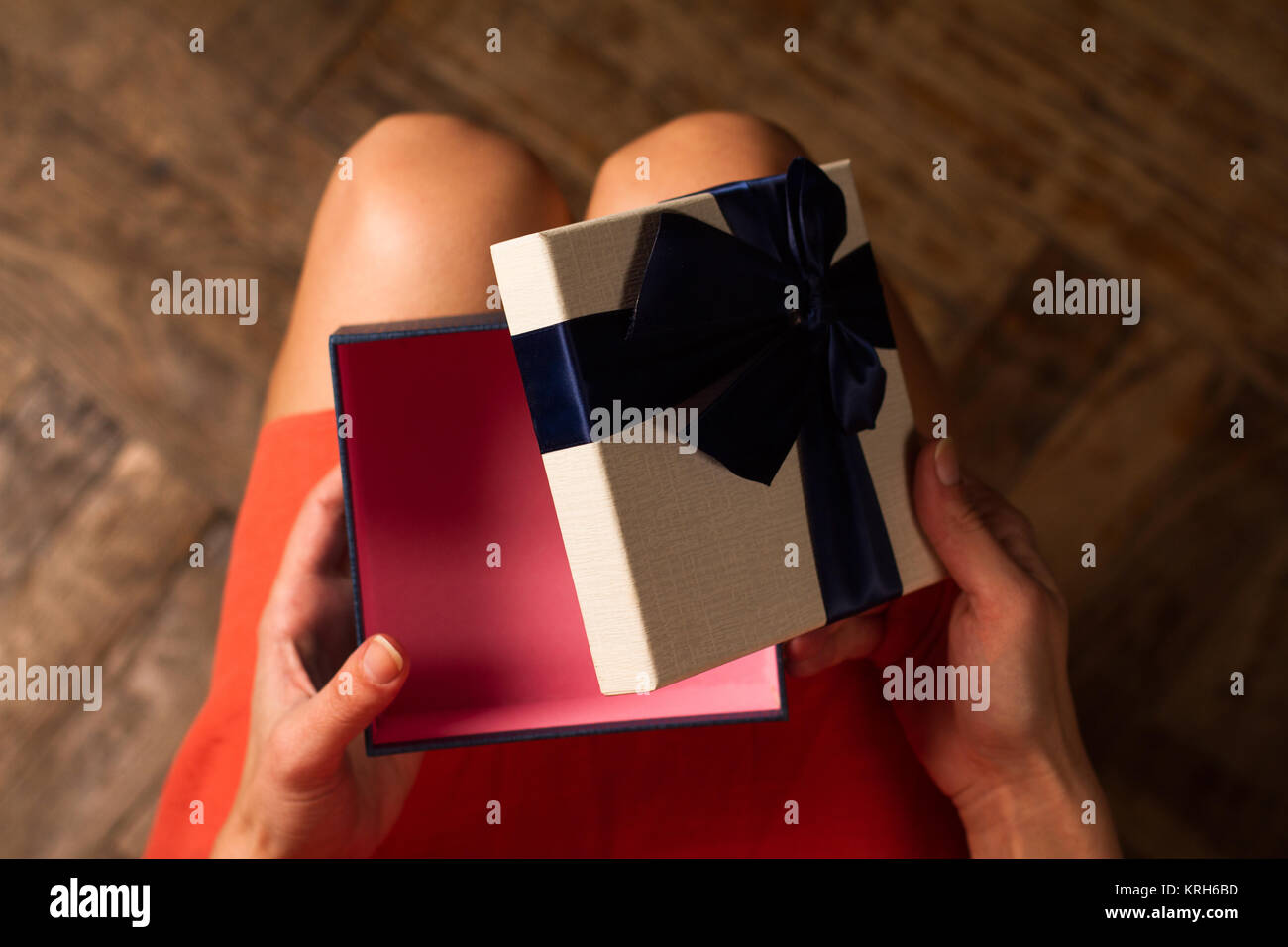 Woman opening a cardboard gift box with blue ribbon Stock Photo - Alamy