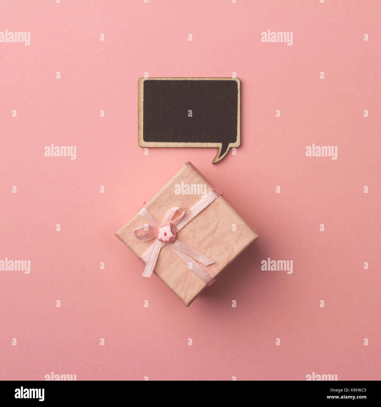 Concept little gift box with wooden speech bubble for messages on pink ...