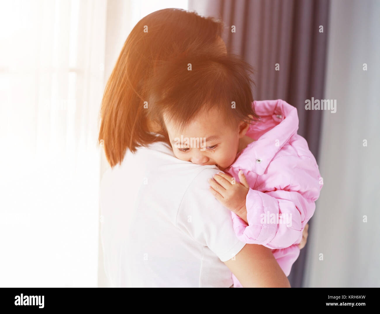 crying baby in the hand of mother at the window Stock Photo - Alamy