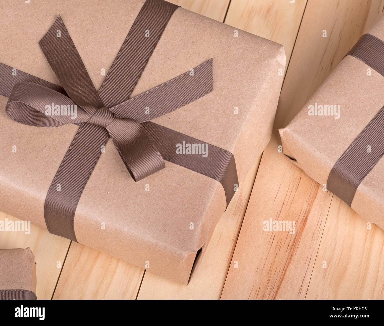 Gift packages wrapped in brown ribbon and bow on wood surface Stock ...