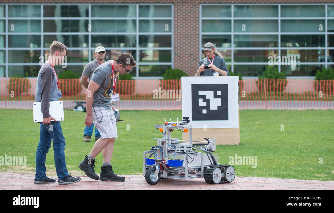 Members of the Army of Angry Robots team follow their robot as it moves ...