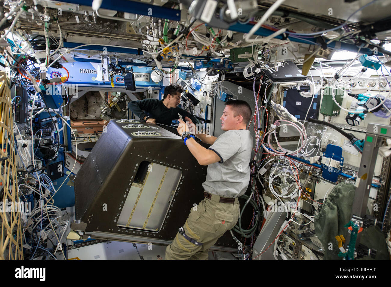 ISS-45 Kimiya Yui and Kjell Lindgren work on a storage rack inside the ...
