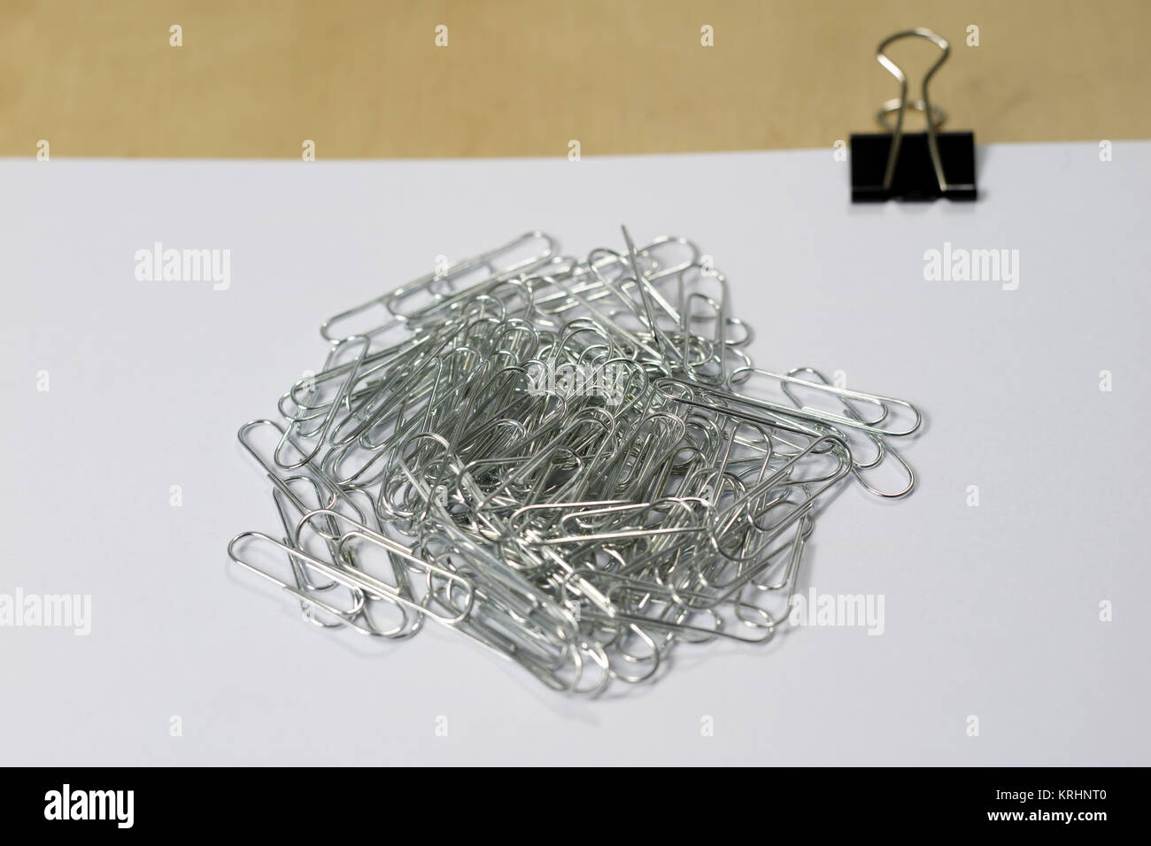 New office paper clips on a white piece of paper. Office accessories ...