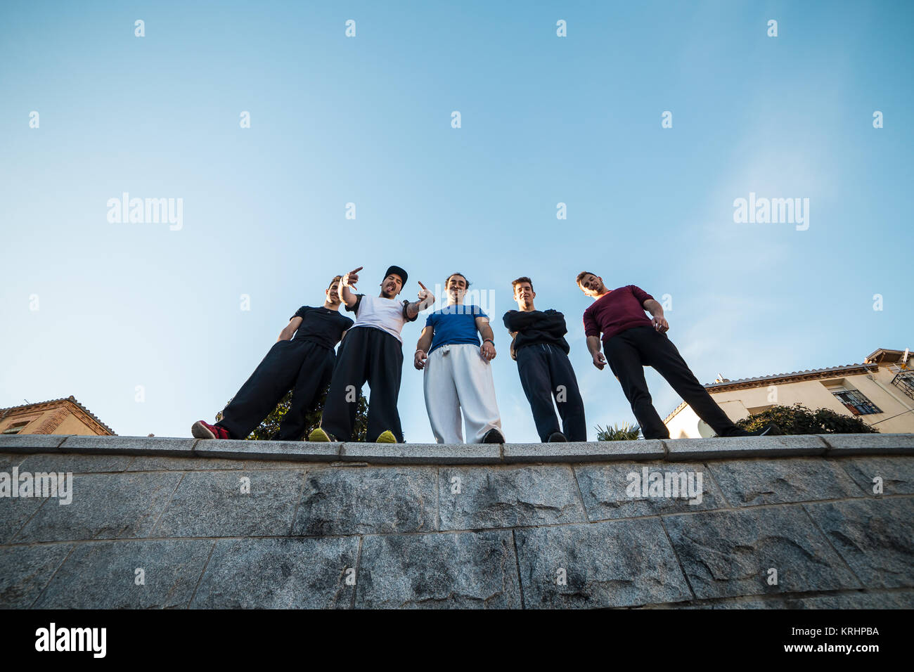 From below group of parkour professionals standing and posing on the ...