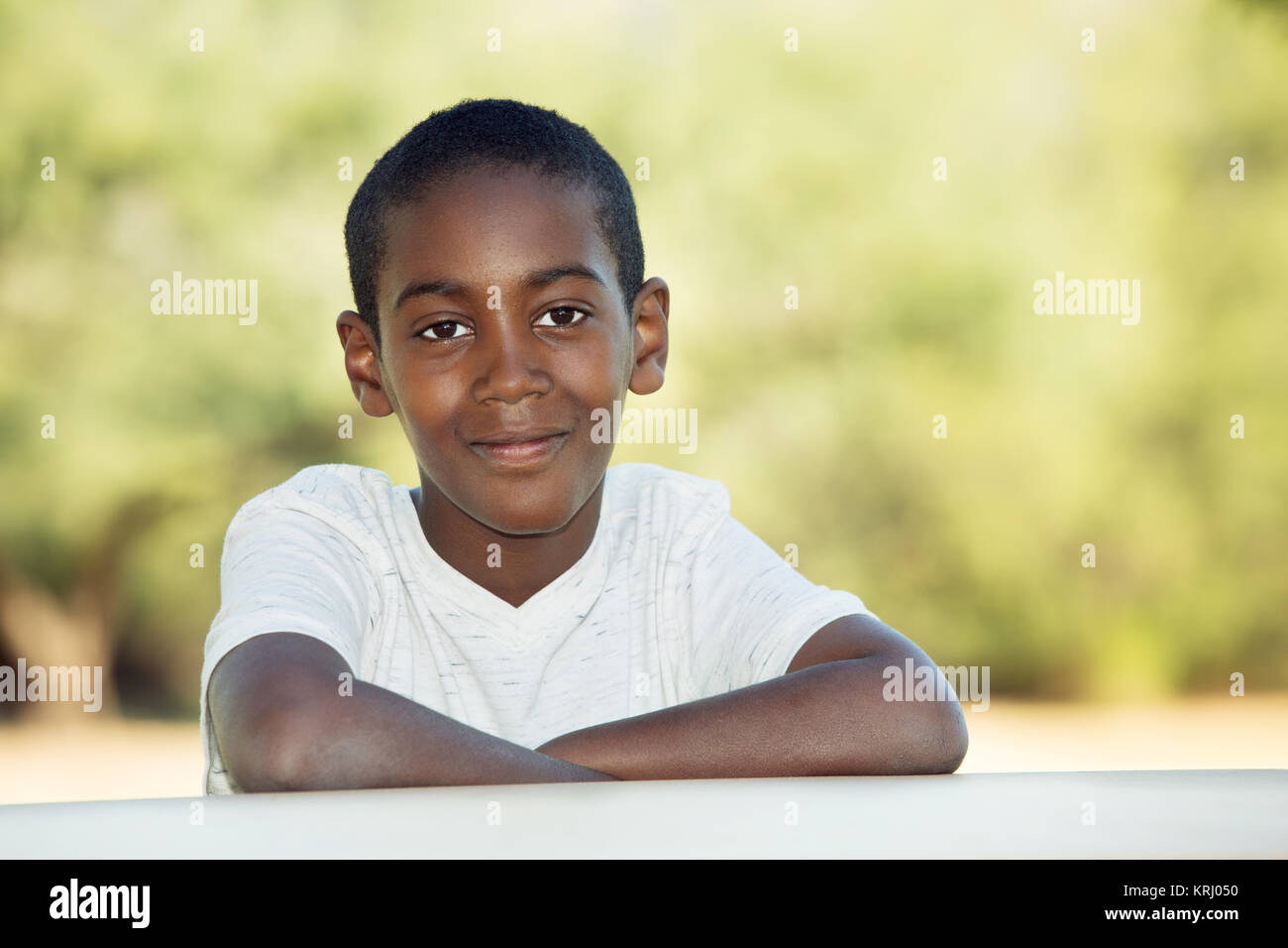 Cute child with folded arms at table Stock Photo - Alamy