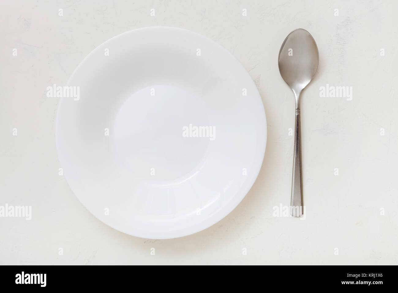 top view of white deep plate and spoon on plaster Stock Photo - Alamy