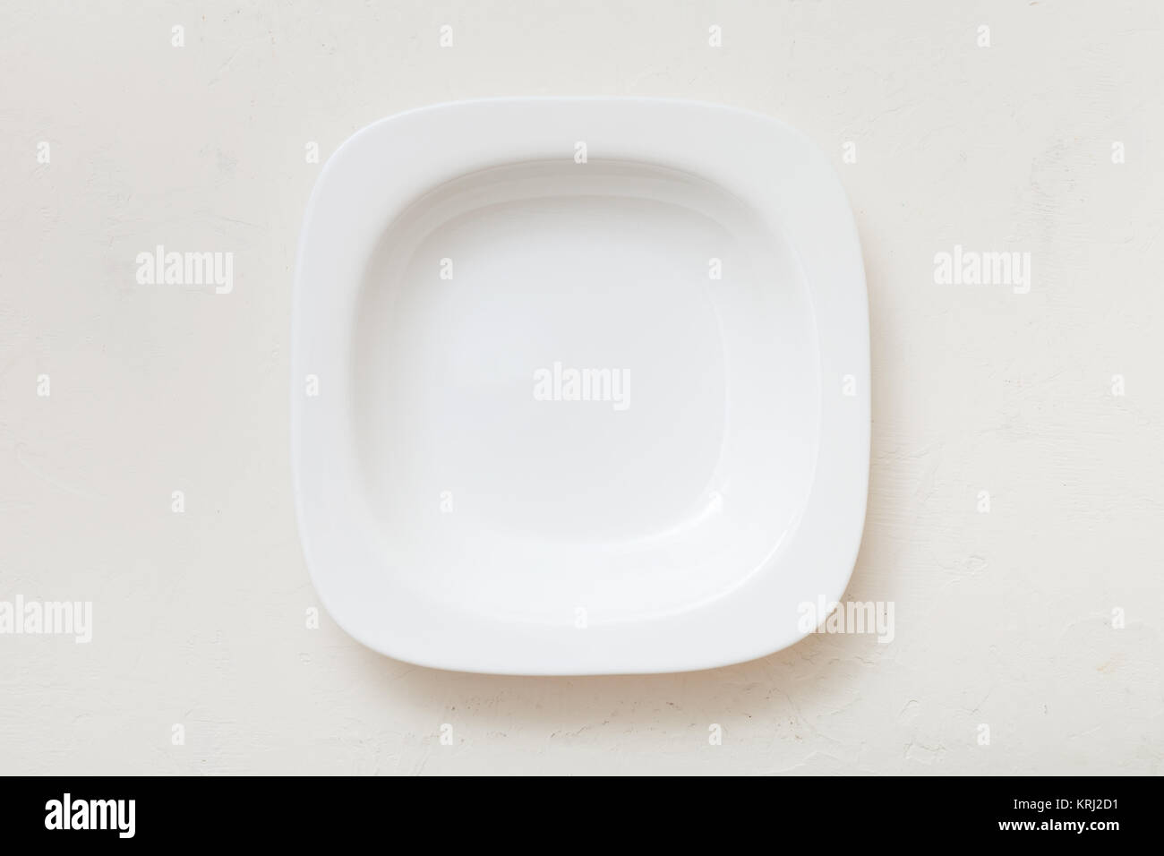 above view of square white deep plate on plaster Stock Photo - Alamy