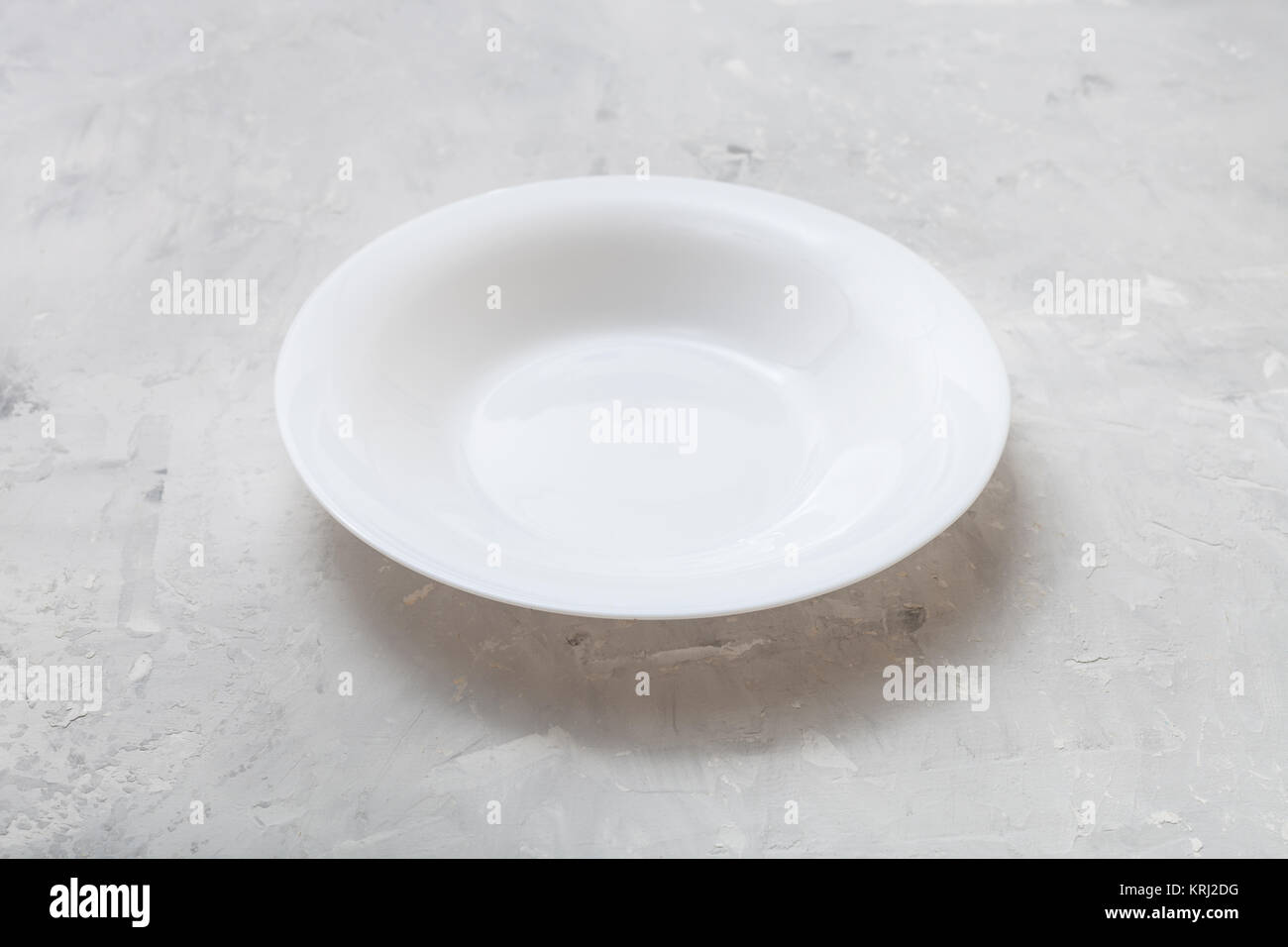 one white deep plate on concrete board Stock Photo - Alamy