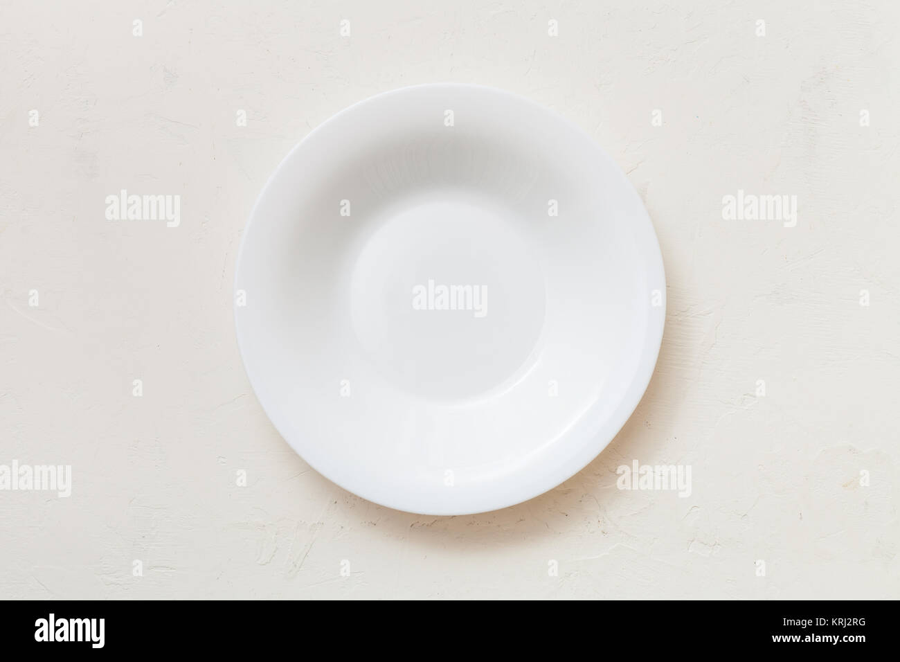 above view of white deep plate on plaster Stock Photo - Alamy