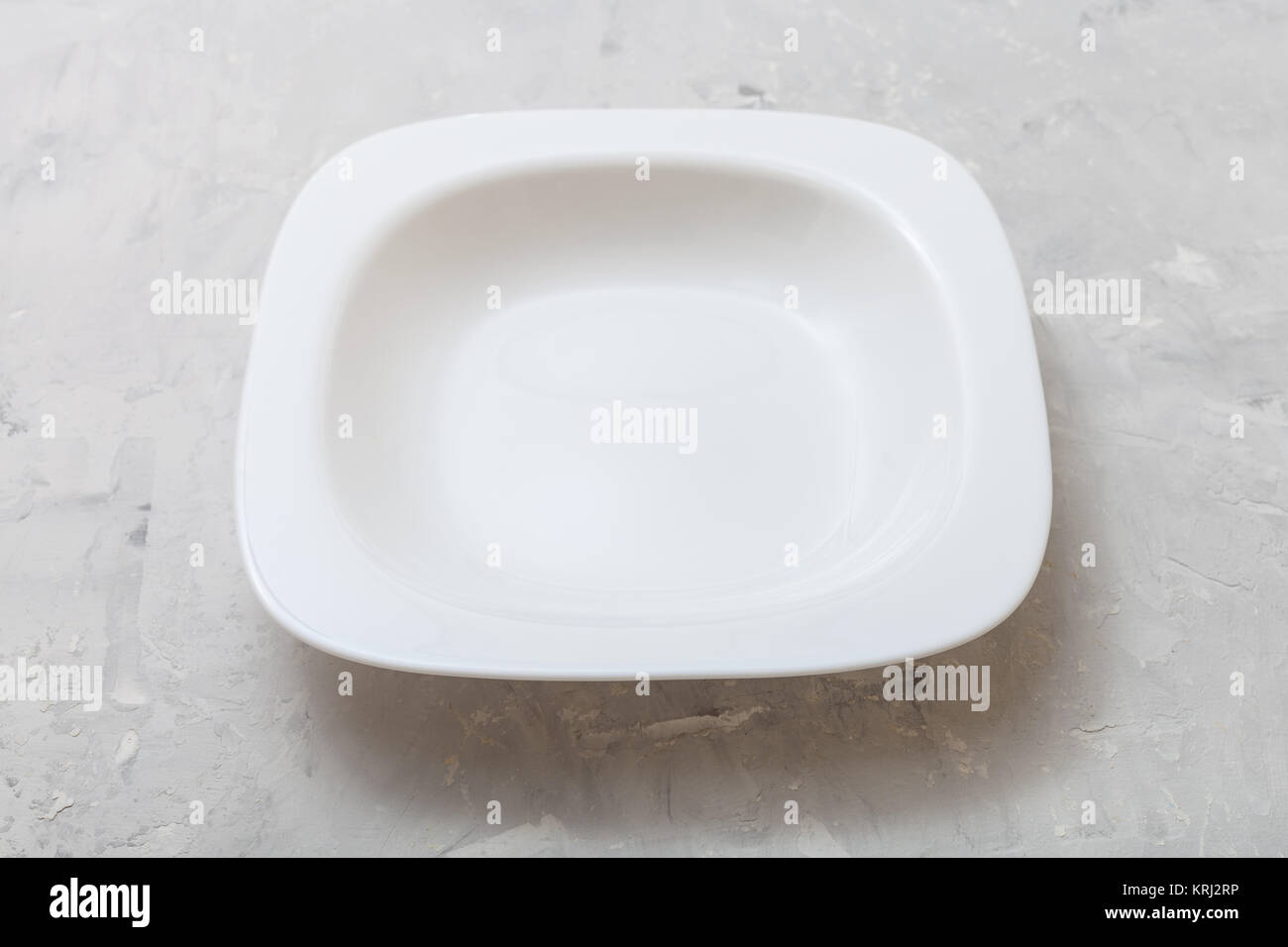 one square white deep plate on gray concrete Stock Photo - Alamy