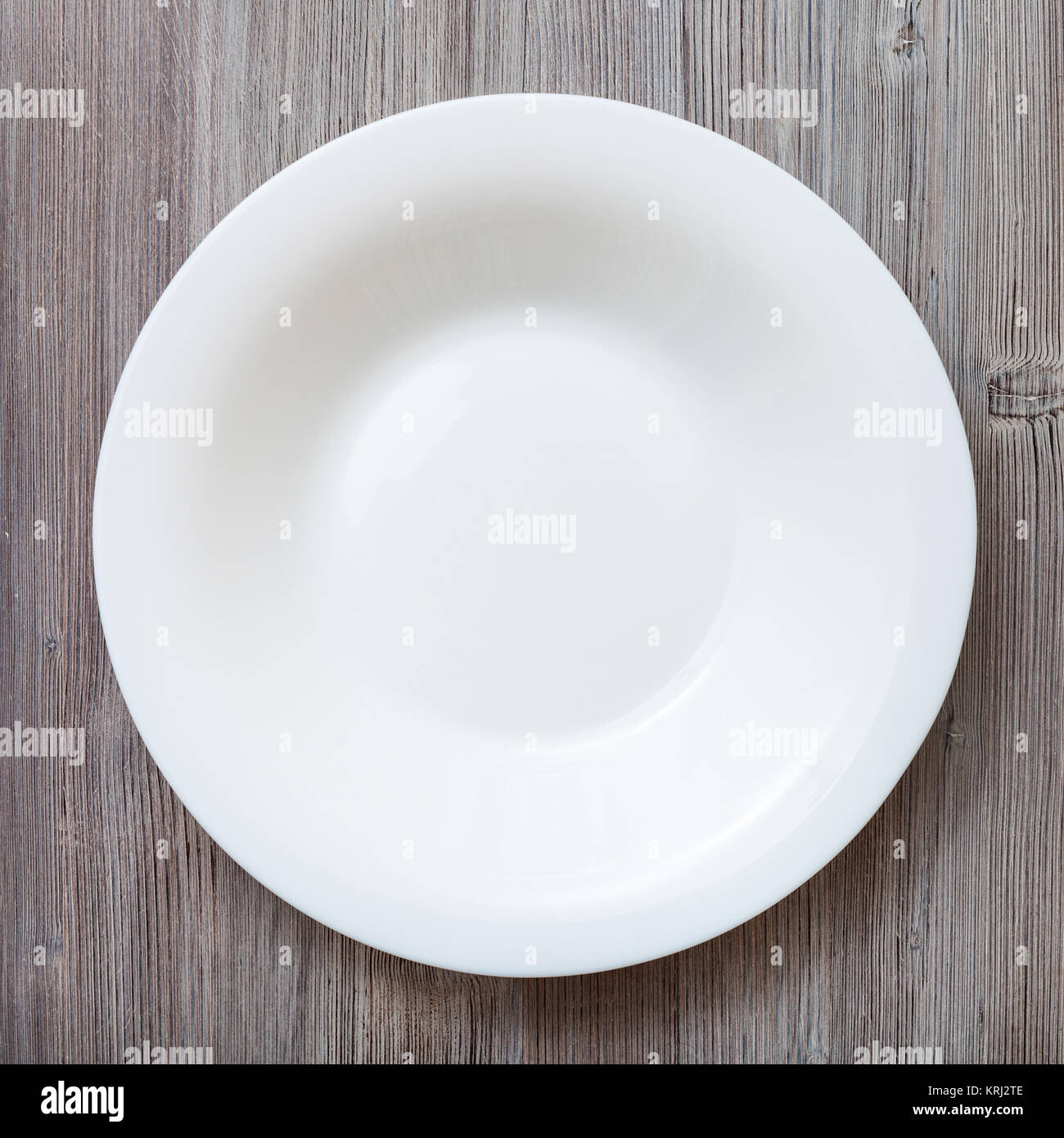 top view of white deep plate on gray brown table Stock Photo - Alamy