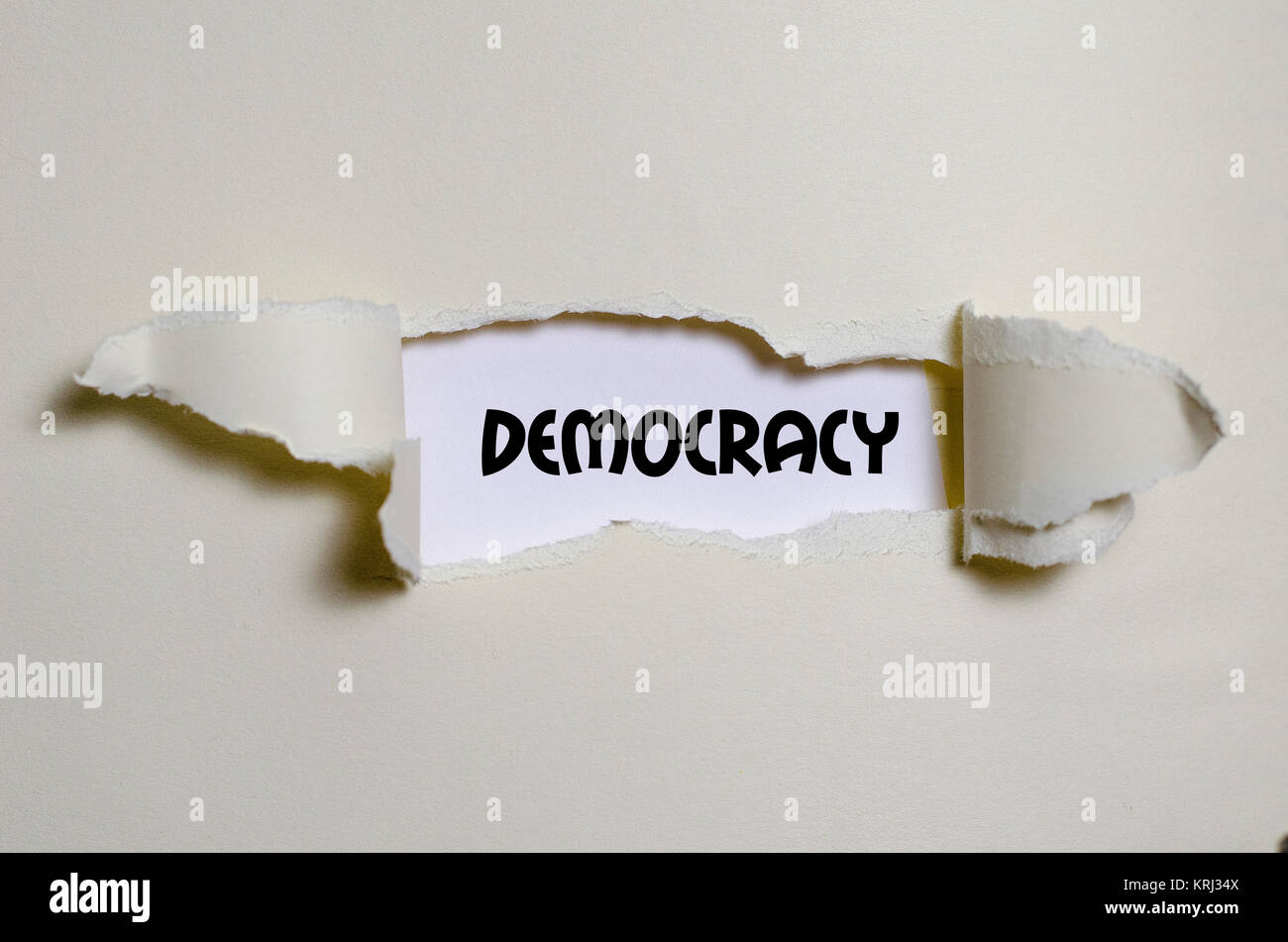 The word democracy appearing behind torn paper Stock Photo - Alamy