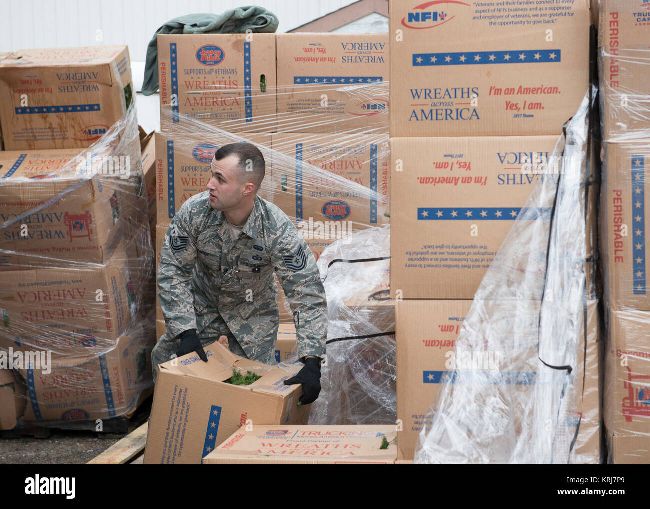 Airmen of the 102nd Intelligence Wing unload a trailer full of wreaths ...